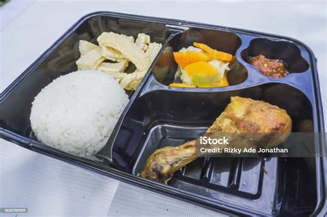 플라스틱 상자 용기에 프라이드 치킨 야채 칠리 소스 삼발 크래커가 들어 있는 나시 코탁 또는 도시락 흰색 배경에 격리되어