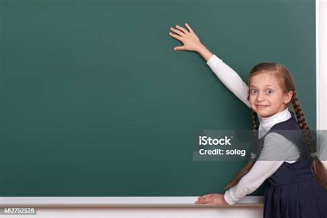 초등학교 여자 손에에 칠판 배경 넣고 클래식 블랙 정장 그룹 학생 교육 개념을 입은 빈 공간 표시 감정 시리즈에 대한 스톡 사진