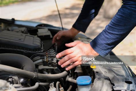 도로 옆에있는 한 남자가 차를 고치고 있습니다 후드에 손을 얹는다 도로에서 자동차 수리 기계 고장 건강 진단에 대한 스톡 사진