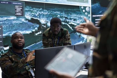 Army Professionals In Command Post Overseeing Satellite Data And Surveillance Stock Image
