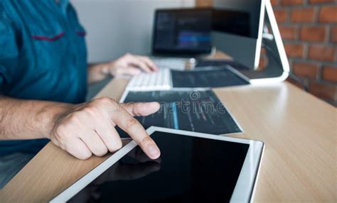 Software Developer Holds The Pen Pointing To The Computer Screen And Is Analyzing The Code Stock