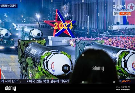 People Watch A Television Screen Showing A News Broadcast With An Image