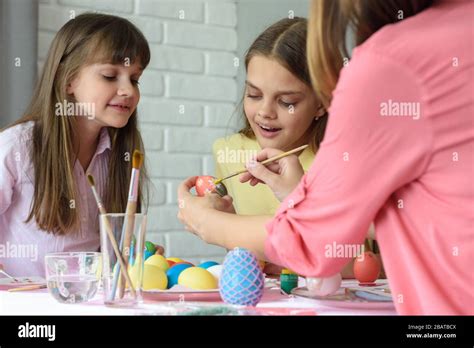 Mom Shows Girls How To Paint Easter Eggs Beautifully Stock Photo Alamy
