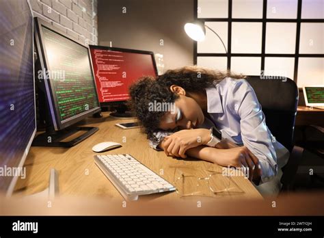 Female African American Programmer Sleeping At Table In Office Stock