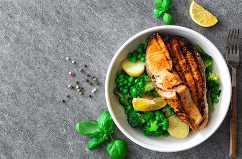 복사 공간 평면도가 있는 어두운 배경에 신선한 연어 스테이크와 야채가 있는 저녁 식사 접시 다이어트 건강 식품 0명에 대한 스톡