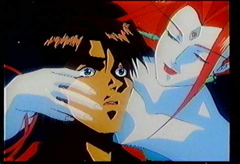 Sharon Apple With Red Hair Leaning Round Isamu With One Hand On His Cheek At Her Concert On Eden