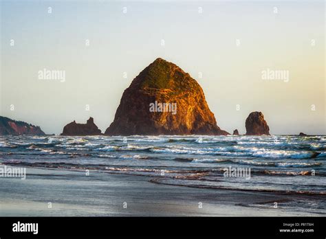 The Haystack Rock At High Tide And At Sunset Famous And Iconic Sea Stack Located In Cannon