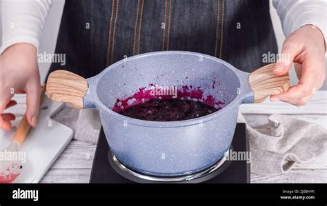 Step By Step Preparing Mixed Berry Compote From Frozen Berries In A Nonstick Cooking Pot Stock