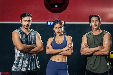 피트니스 체육관에 서있는 활동적인 운동 선수 남성과 여성의 초상화 그룹 경기장에서 건강 관리와 웰빙을 위해 운동 후 행복으로 카메라를 바라 보는 매력적인 젊은 스포츠 사람들