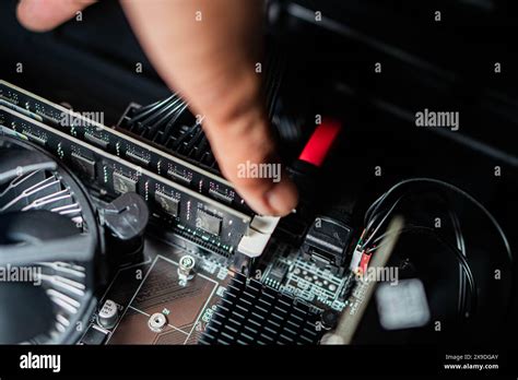 a close up of a person s hand installing or adjusting a ram module on a