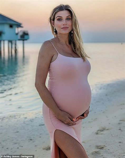 ashley james lovingly cradles her blossoming bump as she enjoys a