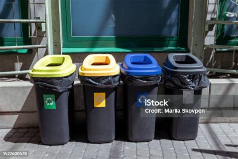 쓰레기를 분류하기위한 다채로운 쓰레기통 플라스틱 유리 종이 및 기타 폐기물 폴란드의 쓰레기 분리를위한 폐기물 용기 벽 옆에 서 있음 쓰레기 수거통에 대한 스톡 사진 및 기타