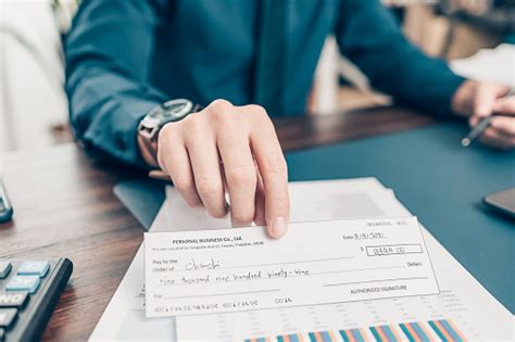 사무실 책상에 고객과 달러 지폐 동전 노트북 및 그래프 차트에 수표를 주는 사업가의 손 수표 급여 급여 개념으로 지불합니다 수표에 대한 스톡 사진 및 기타 이미지 Istock