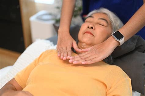 Senior Woman Having Reiki Healing Treatment With Therapist Alternative