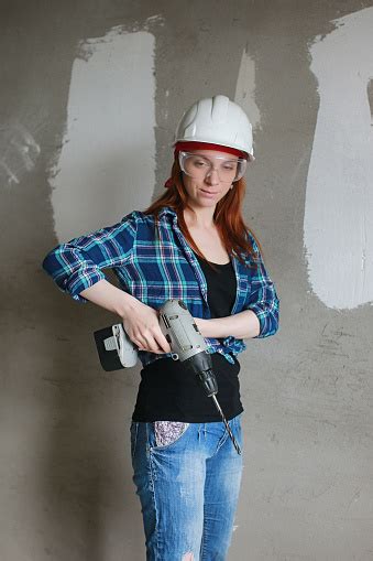 소녀는 아파트에서 수리를하고있다 새 아파트로 이사하는 집 작업자는 수리를 하고 회반죽을 칠하고 벽을 뚫습니다 개선에 대한 스톡