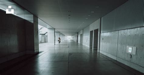 사람이 걸어 내려가는 어두운 복도 사진 Unsplash의 무료 건물 이미지