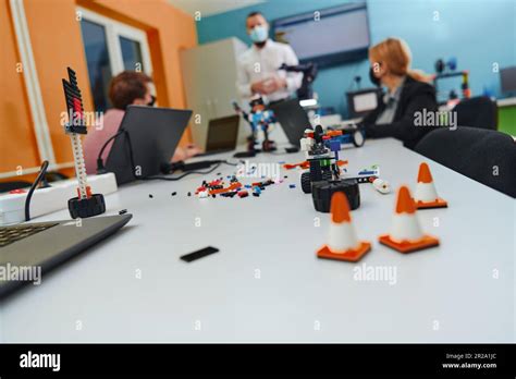A Group Of Colleagues Working Together In A Robotics Laboratory
