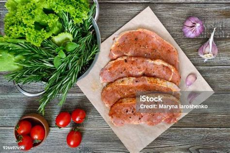 신선 하 고 원시 고기입니다 요리 준비 행에서의 등심 스테이크 나무 테이블에 종이에 향신료와 매 리 네 이드에 생고기의 큰 조각 최고의 볼 수 있습니다 0명에 대한 스톡