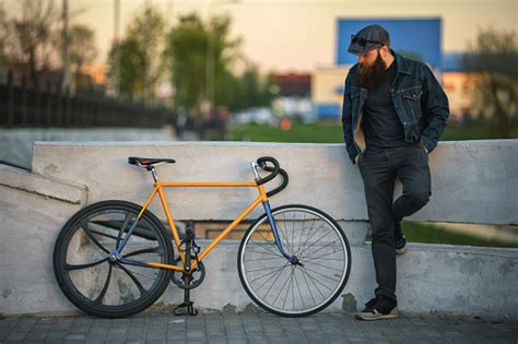 수염 난된 남자와 수정 자전거입니다 선글라스와 모자 일몰에 도시 공원에서 빈티지 자전거를 타고 Gourgeous 큰 수염과 젊은 남자 20 29세에 대한 스톡 사진 및 기타