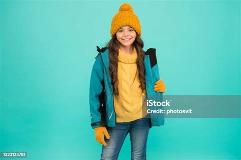 평온한 어린 시절 귀여운 소녀는 겨울 시즌을 즐길 수 있습니다 어린 아이는 니트 모자를 착용합니다 겨울 방학 보호 옷 겨울 컬렉션 아이 착용 모자 장갑 재킷 활동적인 레저