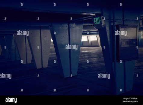 A Dark Parking Garage Featuring A Lit Exit Sign On The Column Stock Photo Alamy