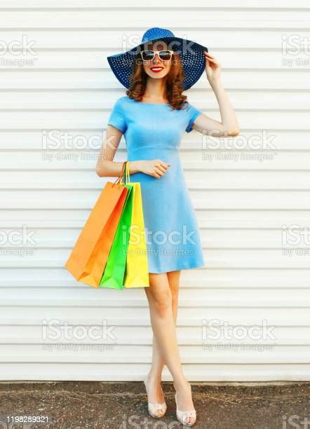 파란색 드레스 여름 밀짚 라운드 모자와 흰색 벽 배경 위에 선글라스를 입고 쇼핑 백 전체 길이 아름다운 젊은 여성 모델 쇼핑백에 대한 스톡 사진 및 기타 이미지 Istock