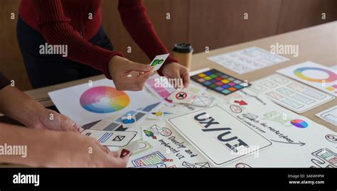 Interactive Design Elements In UX UI A Group Collaborates Around Design Materials Examining