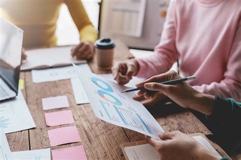 재무 그래프 데이터 및 마케팅 계획을 설명하는 비즈니스 담당자 회의 회의에서 비즈니스 사람들의 그룹은 비즈니스 투자 및 마케팅의