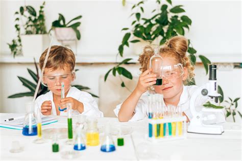 실험실에서 화학 실험을 수행하는 흰색 유니폼을 입은 진지한 어린 소년과 소녀 학교 개념으로 돌아 가기 젊은 과학자 자연과학 유치원 및 아동의 학교 교육 2명에 대한 스톡