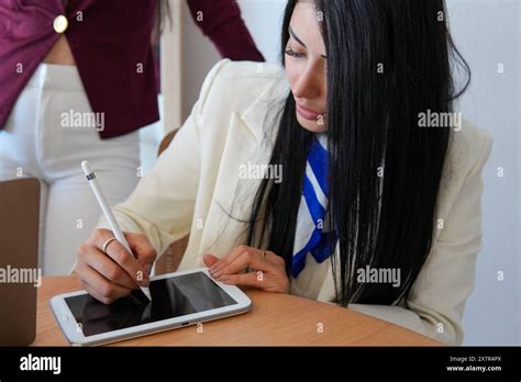 A Professional Woman Engages Intently With A Digital Tablet While Working From Home