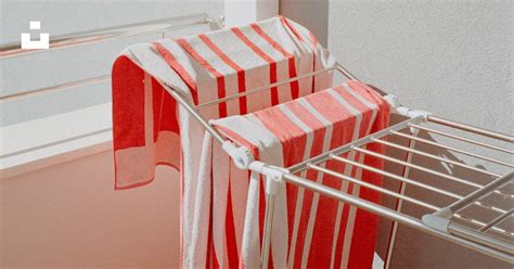 빨간색과 흰색 줄무늬 수건 두 장이 와이어 랙에 있습니다 사진 Unsplash의 무료 건조대 이미지