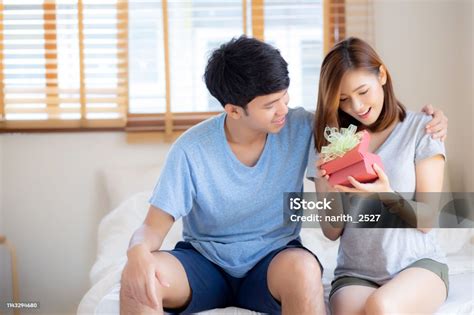 아름 다운 젊은 아시아 커플 집에서 침실에서 깜짝 선물 상자 사랑 가족과 함께 결혼 기념일과 함께 아내와 남편과의 관계 발렌타인