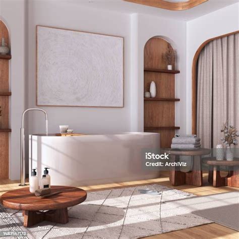 흰색과 베이지색 톤의 커튼 욕조 테이블 카펫이 있는 현대적인 목재 욕실 쪽모이 세공 마룻바닥과 아치형 문 Japandi 인테리어 디자인 0명에 대한 스톡 사진 및 기타