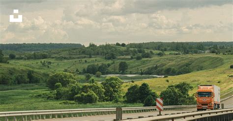 무성한 녹색 언덕 옆의 고속도로를 달리는 트럭 사진 Unsplash의 무료 자연 이미지