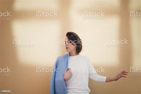 블루 코트 도시 산책에 닫힌 그녀의 눈에 젊은 부드러운 미소 갈색 머리 여자는 그녀의 손을 파도 태양 노란 벽에 반사입니다 4월에 대한 스톡 사진 및 기타 이미지 Istock