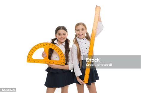 공과를 준비중입니다 공과를 위해 트랙터와 통치자를 들고 귀여운 여학생 기하학 수업을 준비하는 어린 소녀 학교 수업에서 측정 장비를 가진 어린 아이들 2명에 대한 스톡 사진
