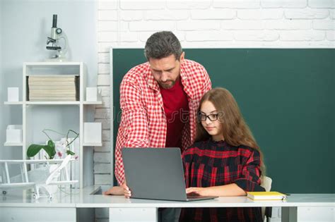 Teacher Helping Elementary School Pupils In Computer Class Learning With Laptop Elementary