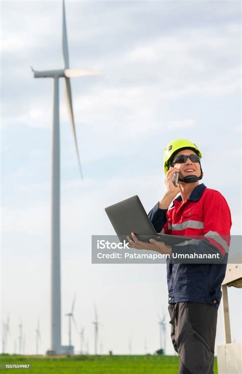 광대한 풍력 터빈 농장에서 일하는 기계 엔지니어는 노트북을 사용하여 중요한 매개변수를 모니터링하고 풍력 터빈을 살펴봅니다 최적의