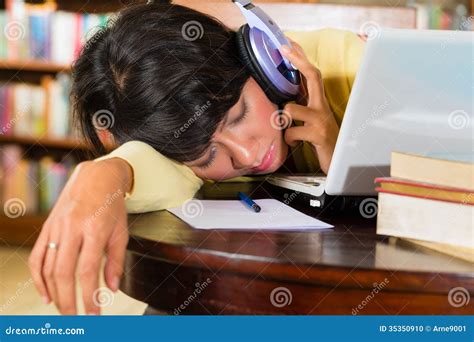 Ragazza In Biblioteca Con Il Computer Portatile E Le Cuffie Fotografia Stock Immagine Di