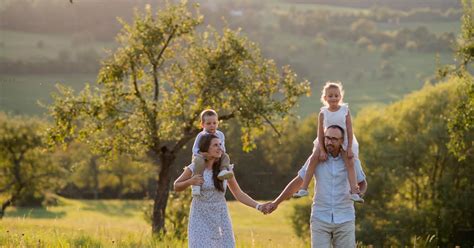 해질녘 야외 초원을 걷고 있는 두 명의 어린 자녀와 함께 피기백 타기를 하는 가족의 전면 보기 사진 Unsplash의 자연 이미지