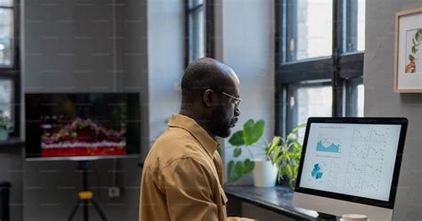 사무실에서 책상 옆에 앉아 컴퓨터 앞에서 재무 데이터를 다루는 캐주얼 옷을 입은 젊은 현대 경제학자 사진 Unsplash의 그래프 이미지