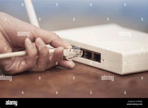 Human Hand Plugging Patchcord To The Wireless Modem Stock Photo Alamy