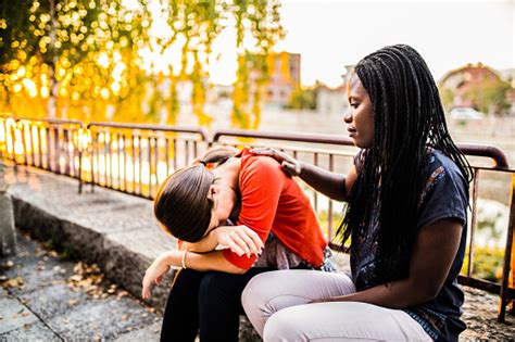 도시 공원의 강 근처에 앉아 백인 여성을 위로하는 흑인 여성 25 29세에 대한 스톡 사진 및 기타 이미지 25 29세 2