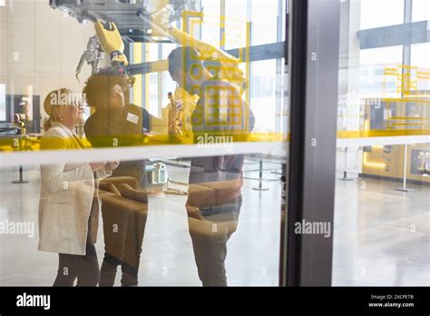 Group Of Engineers Discussing Robotics And Automation In A Modern Industrial Facility Concept