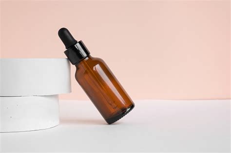 호박색 유리 점적기 화장품 병 흰색 연단 자연 스킨 케어 Spa 뷰티 제품 디자인 베이지 색 배경에 미네랄 유기농 오일 모형 기름진 피펫 얼굴과 몸 치료 정면보기 0명에