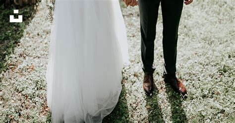 하얀 웨딩드레스를 입은 여자와 낮 동안 푸른 잔디에 서 있는 검은 양복을 입은 남자 사진 Unsplash의 무료 여자 이미지