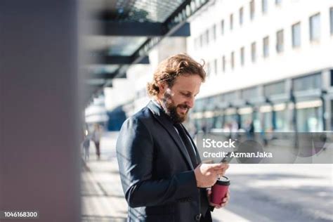 스마트 휴대 전화를 사용 하 여 고 버스 정류장에 커피 한잔 들고 사업가 버스 정류장 건축물에 대한 스톡 사진 및 기타 이미지 버스 정류장 건축물 남자 40 49세