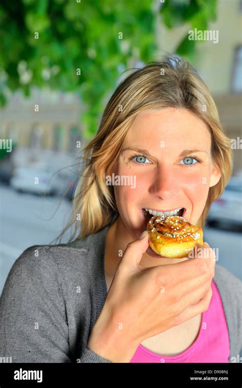 Woman Eating A Bun Stock Photo Alamy