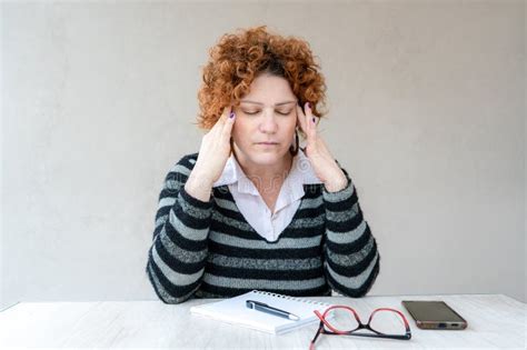 A Mid Adult Redhead Woman With A Headache Is Rubbing Her Temples Stock Image Image Of