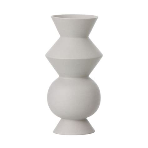 A Tall White Vase Sitting On Top Of A Table